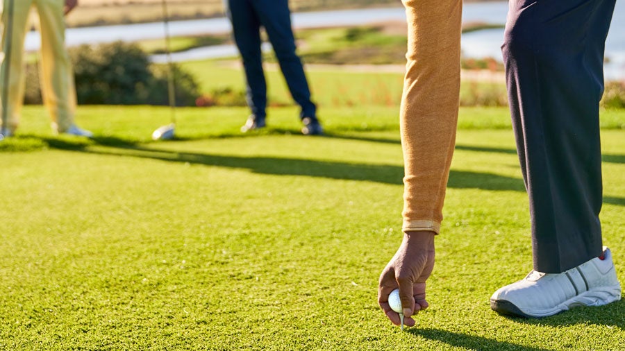 Where should you stand on the tee box when your partner is hitting?